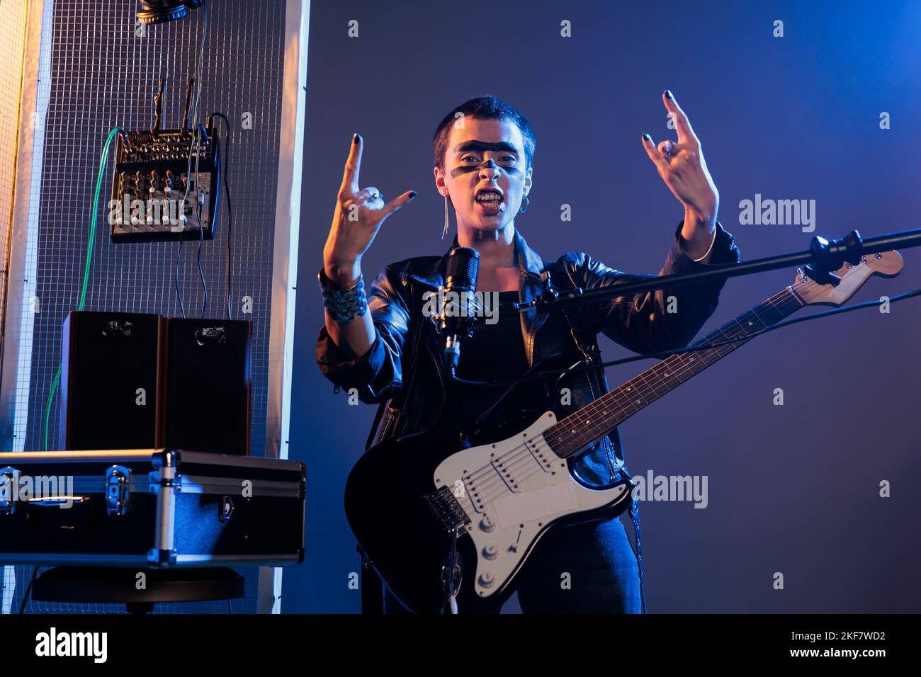 Cool artist doing rock sign on live performance, singing loud ...