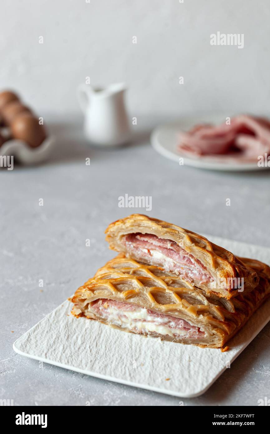 puff with ham and cheese cut on a rectangular plate on a kitchen table ...