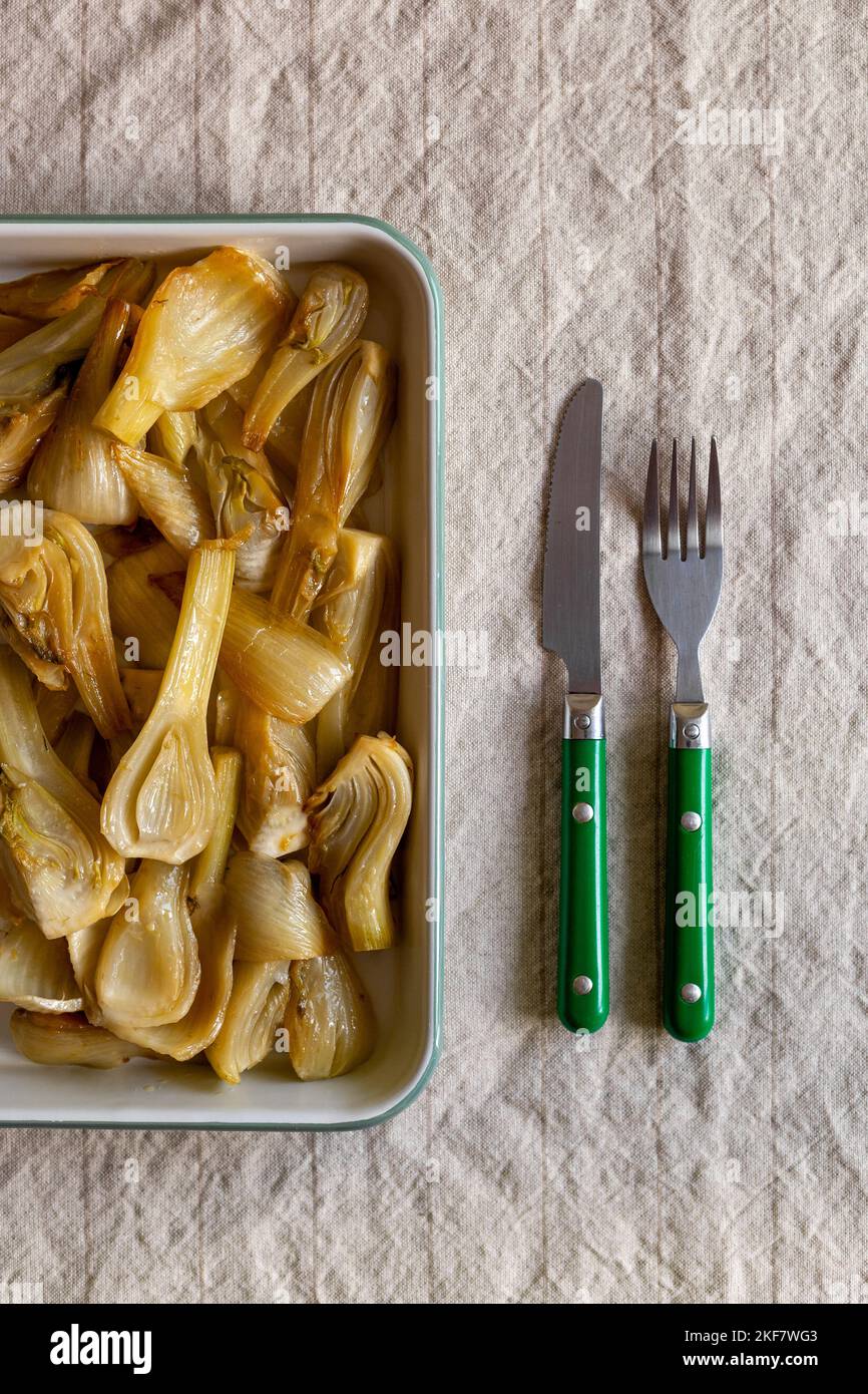 baked fennel dish on a kitchen table napkin, cutlery, top view Stock ...
