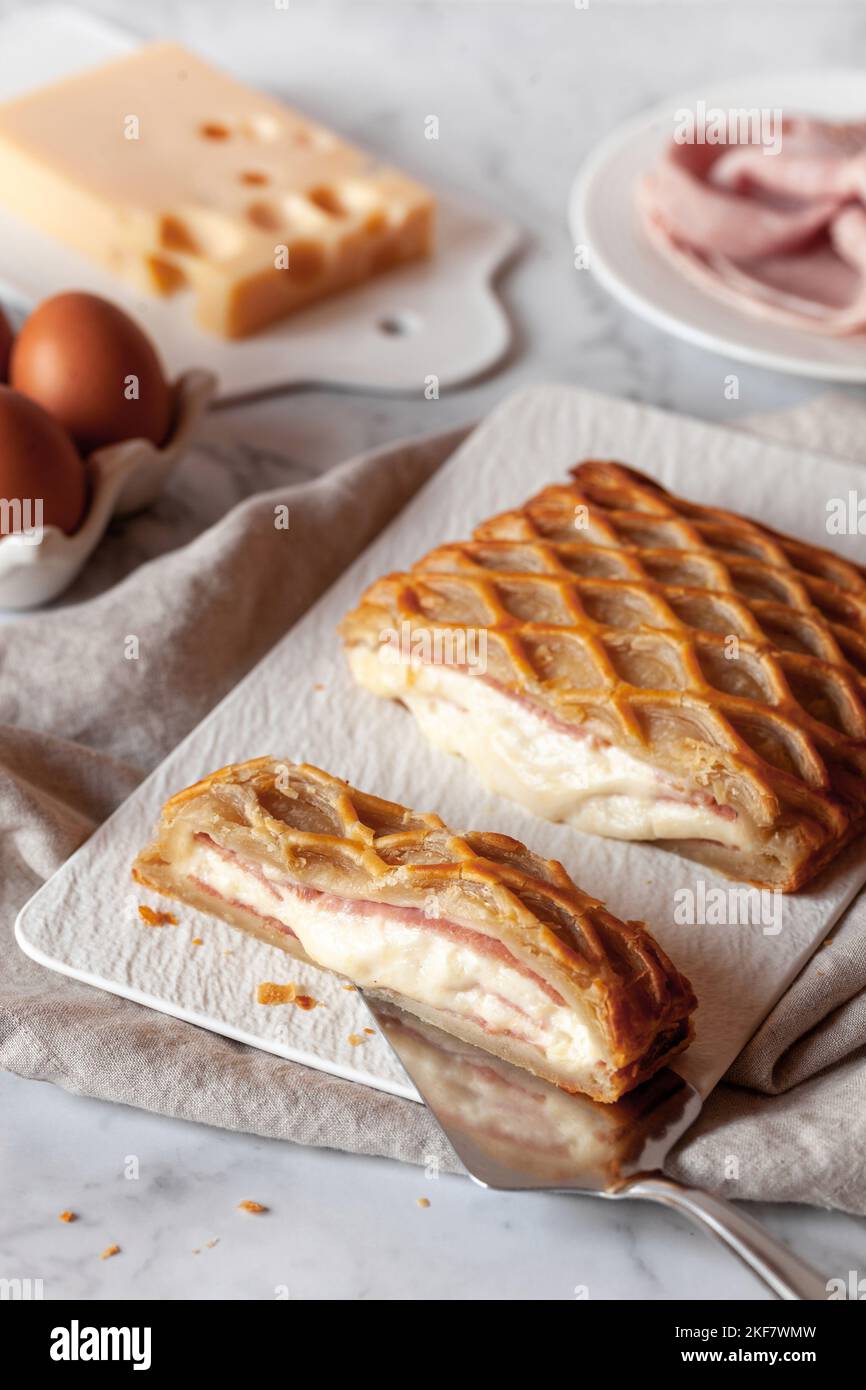 serving puff with ham and cheese cut on a rectangular plate on a ...