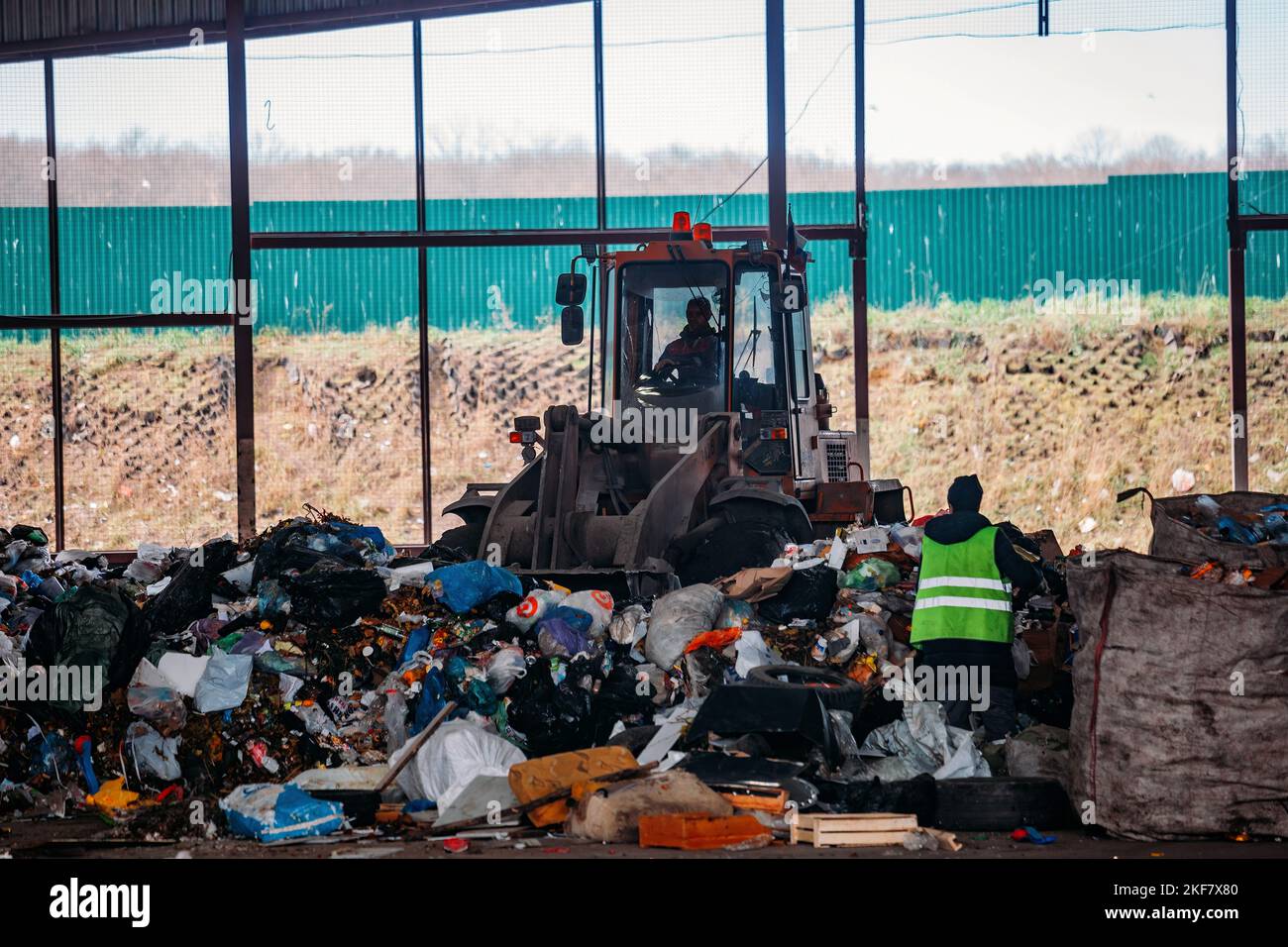 Bulldozer working at waste processing plant. Process sorting of garbage ...