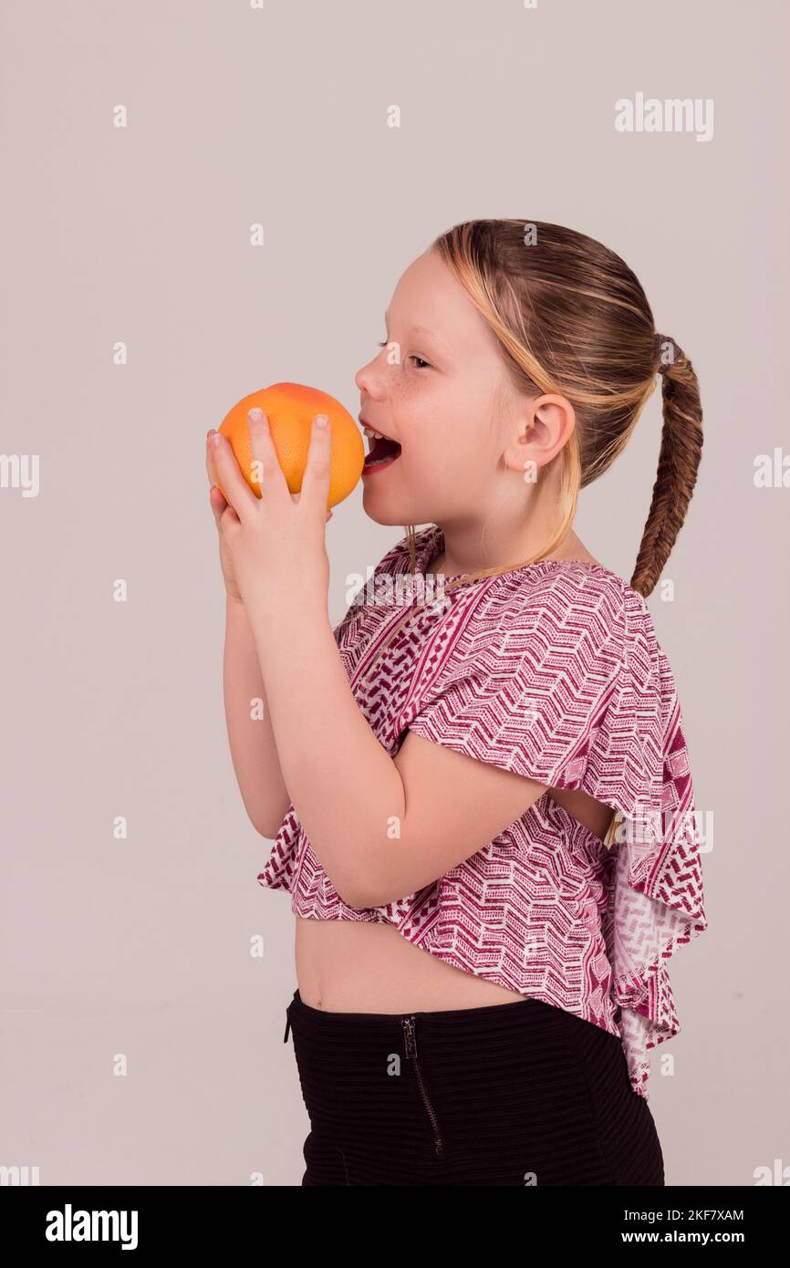The girl eats grapefruit and laughs. Healthy eating, diet Stock Photo ...