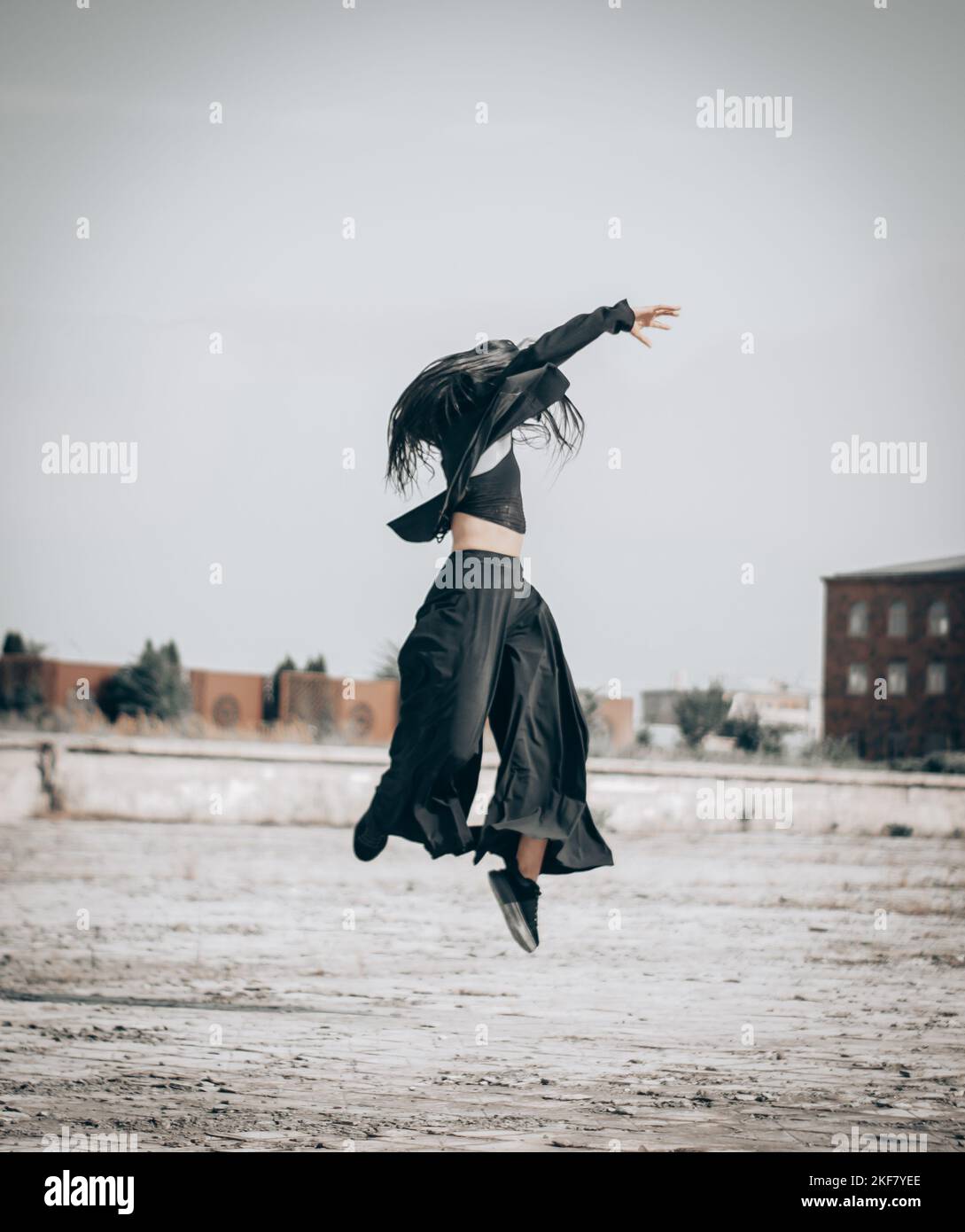 A dancer jumping in the air with black clothes on - concept of ...