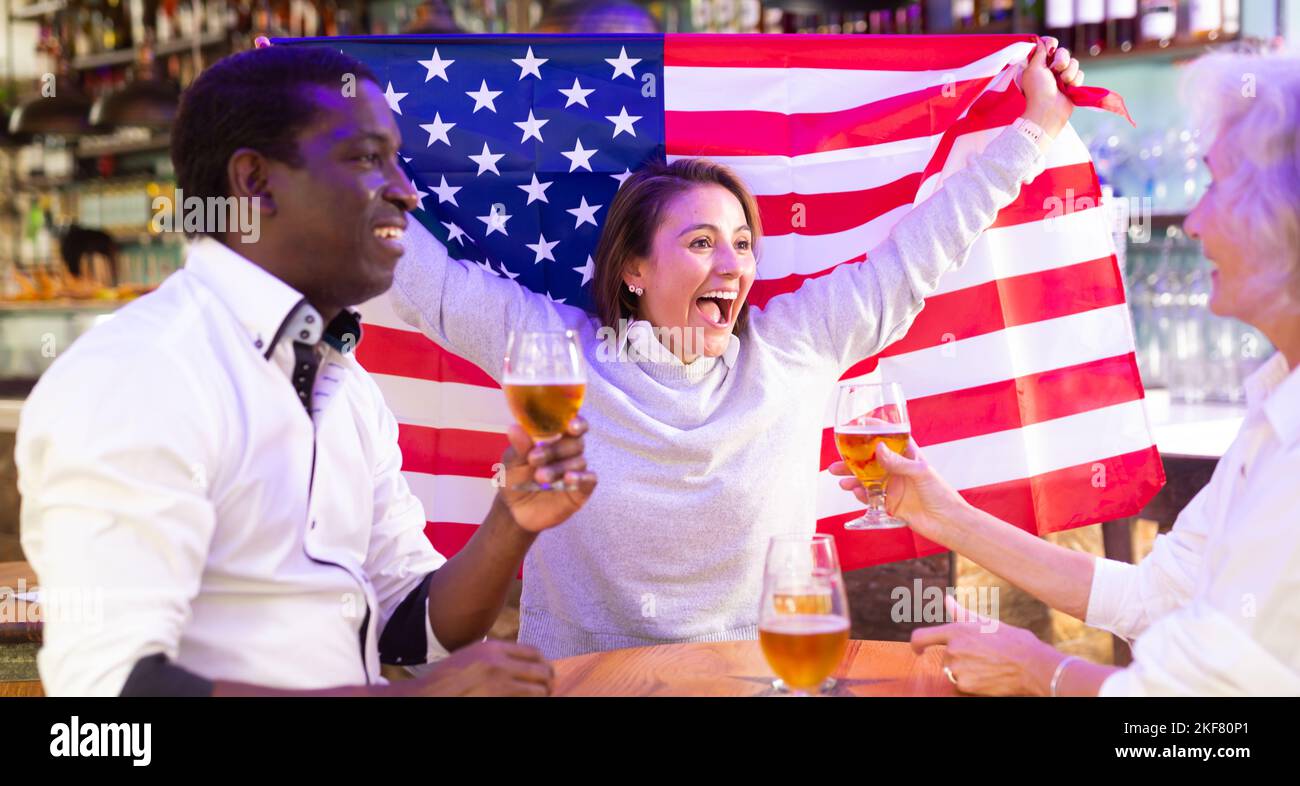 Happy international sport supporters holding up the flag of USA and ...