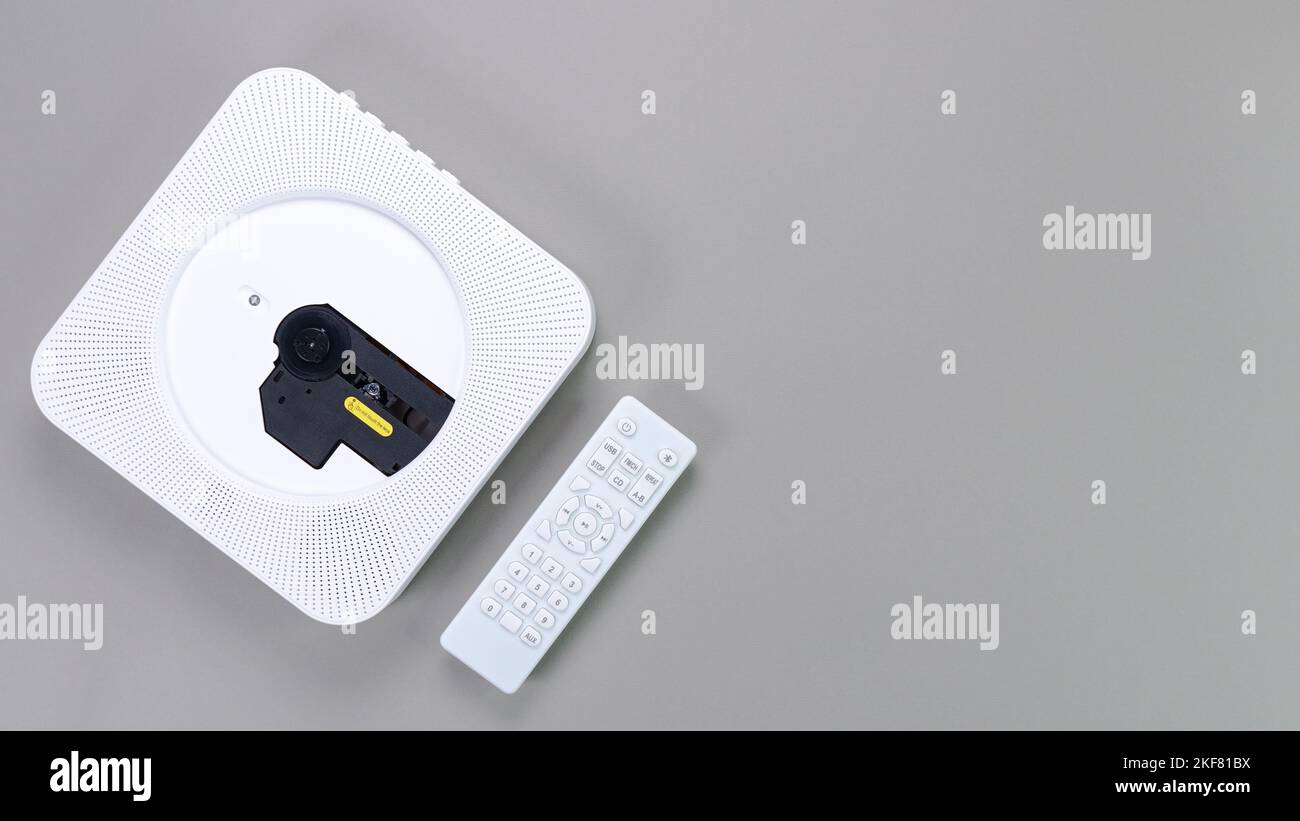 Stylish white portable compact CD player with controller on grey ...