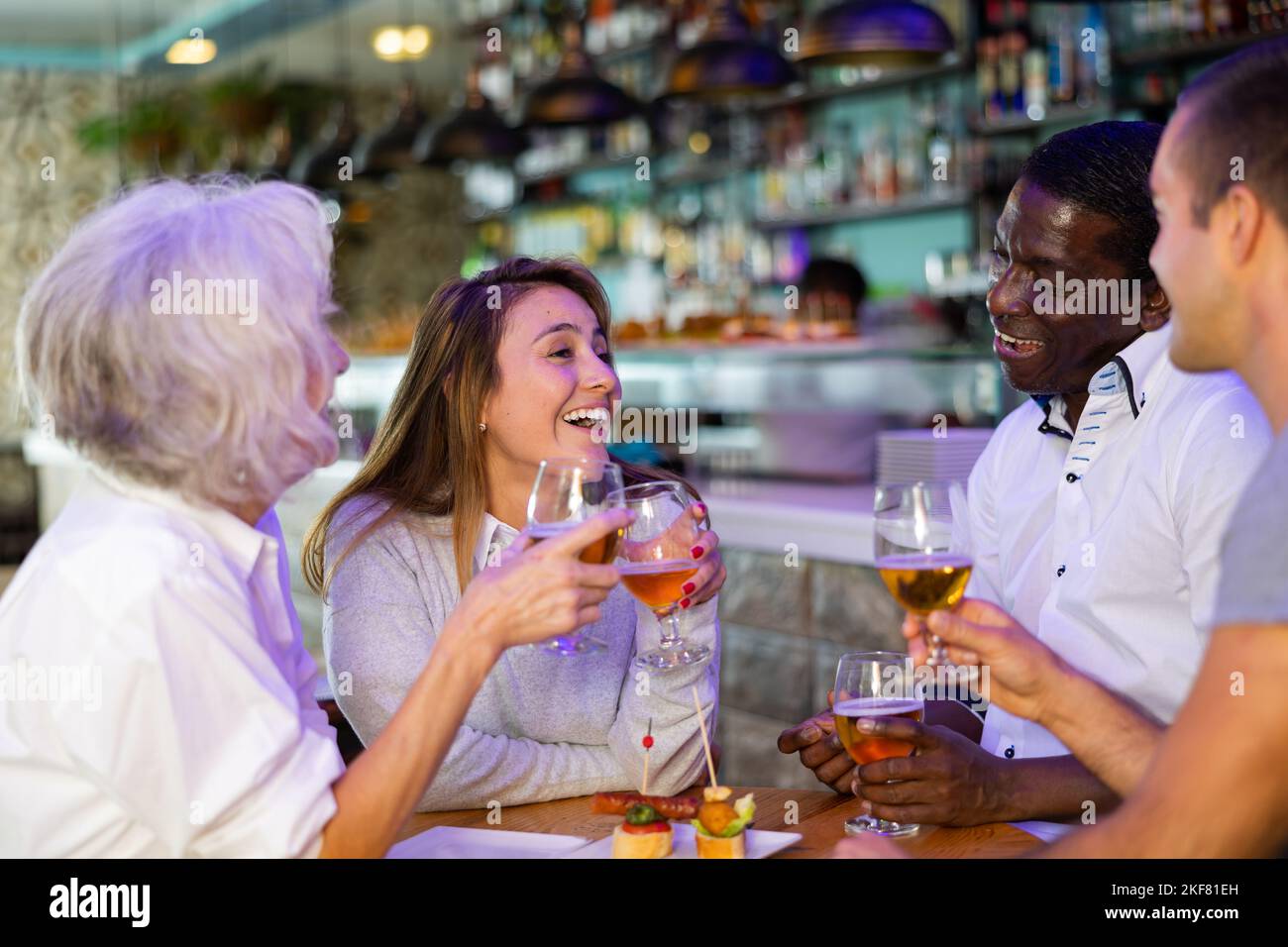 Diverse friends talking and laughing at a pub Stock Photo - Alamy