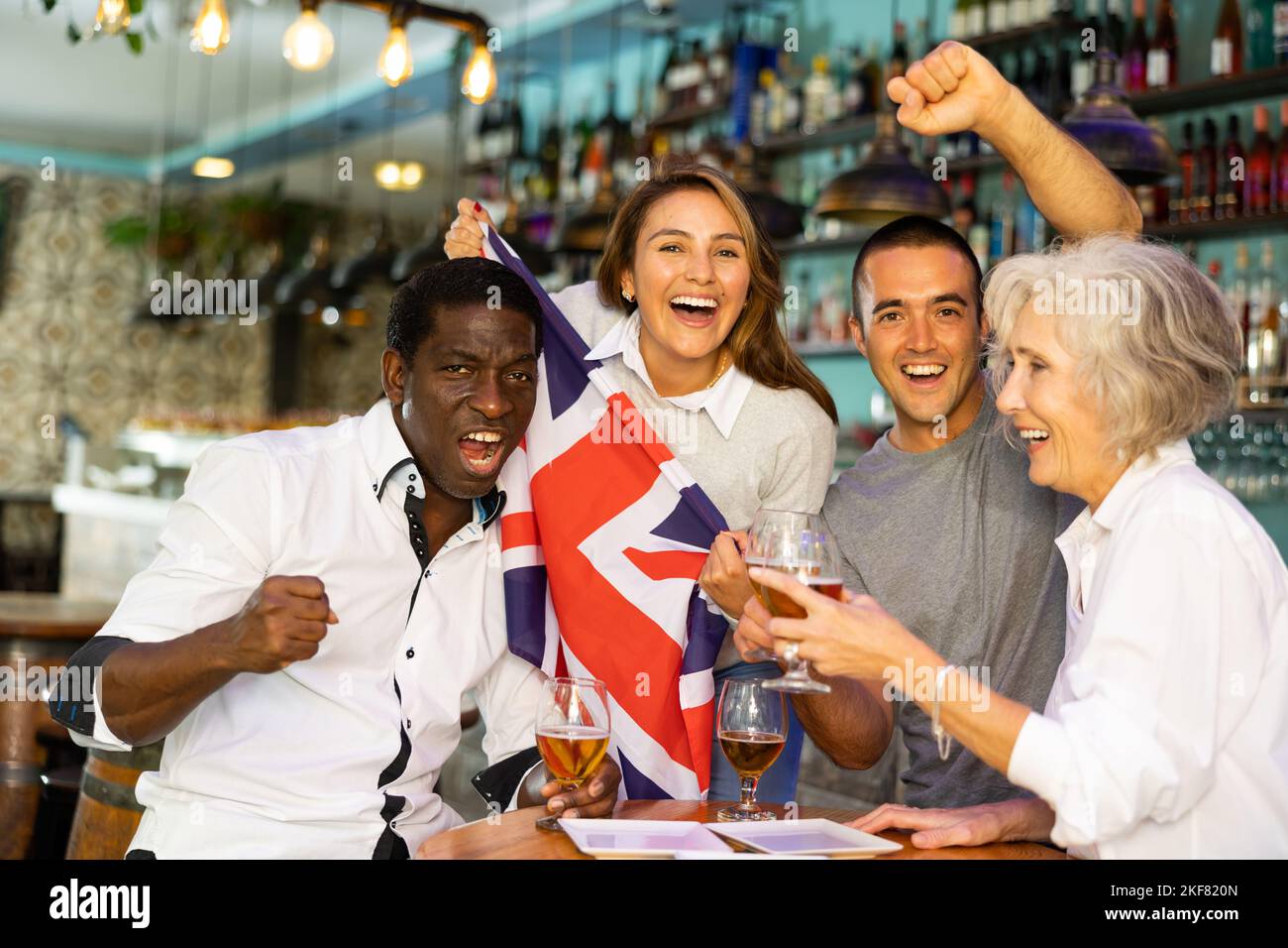 International group of people with UK flag toasting with beer, having ...