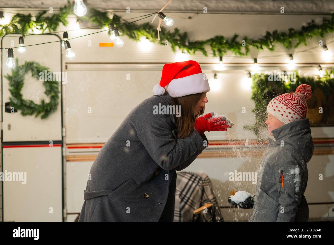 Caucasian woman playing snowballs with her son at the camper Stock ...