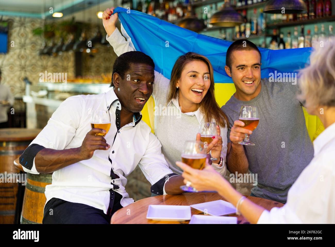 Happy international sport fans waving Ukrainian flag while watching ...