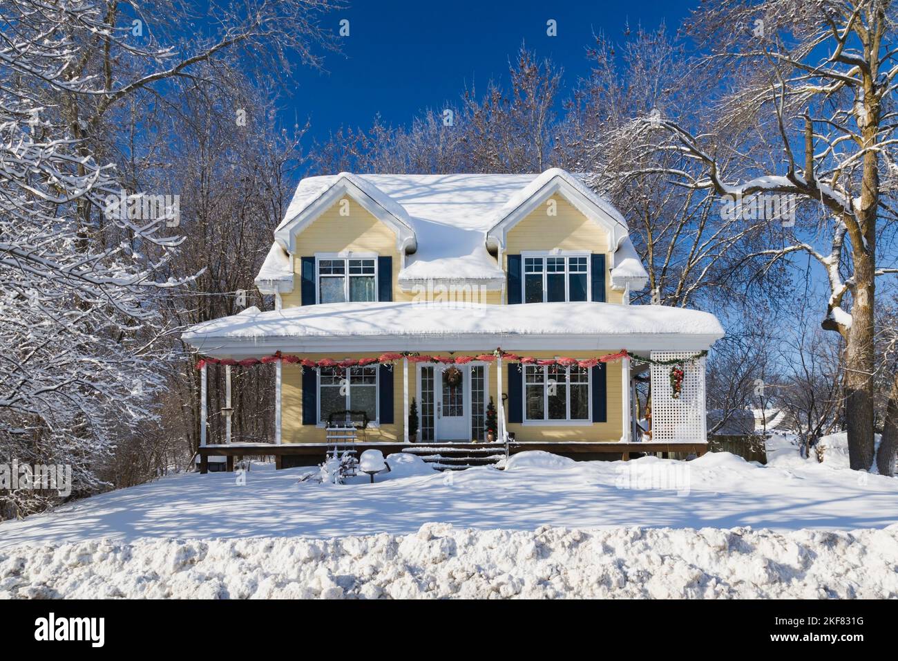Yellow clapboarded with blue and white trim cottage style home facade ...