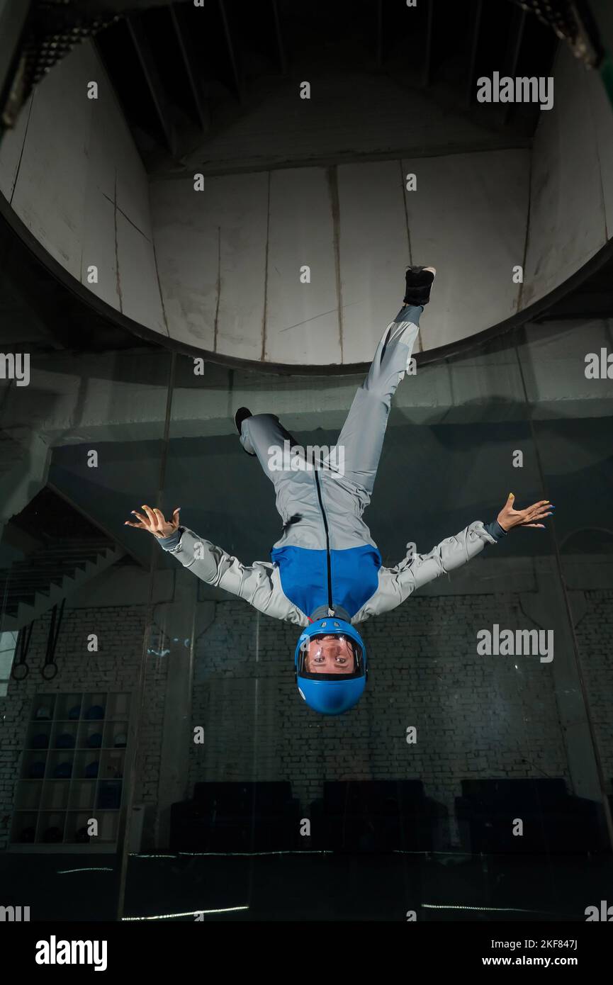 A woman flies in a wind tunnel. Free fall simulator Stock Photo - Alamy