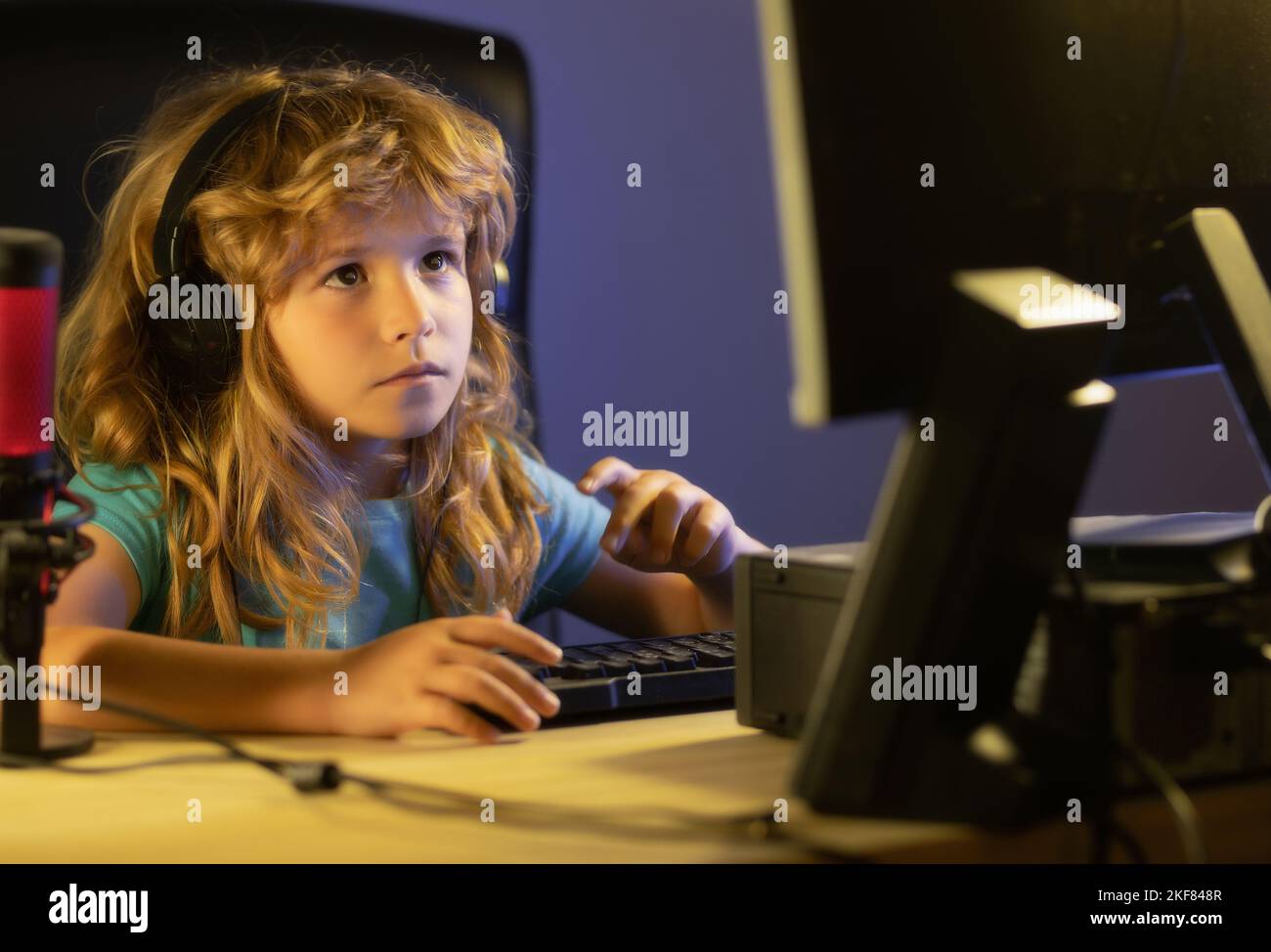 Child plays a video game on the pc computer screen. Portrait of cute ...