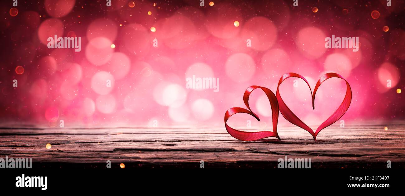 Two Ribbon Hearts On Rustic Wooden Table With Glowing Bokeh Background ...