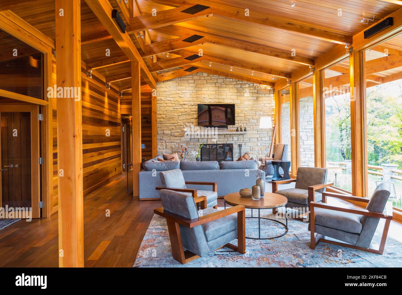 Brown wooden and grey upholstered sitting chairs, round table and sofas ...