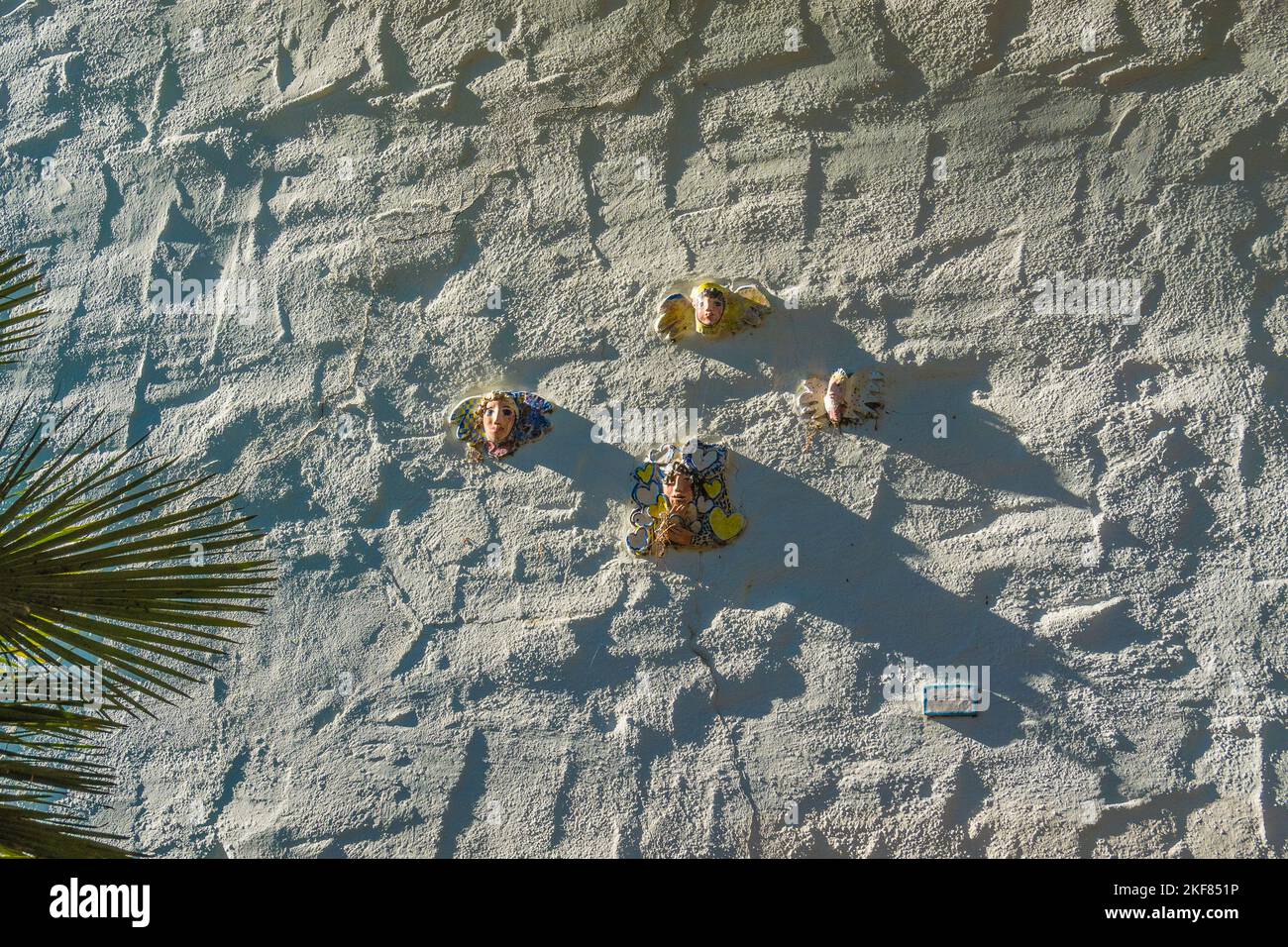 Faces of ceramic people attached to a stucco wall by Santa Barbara ...