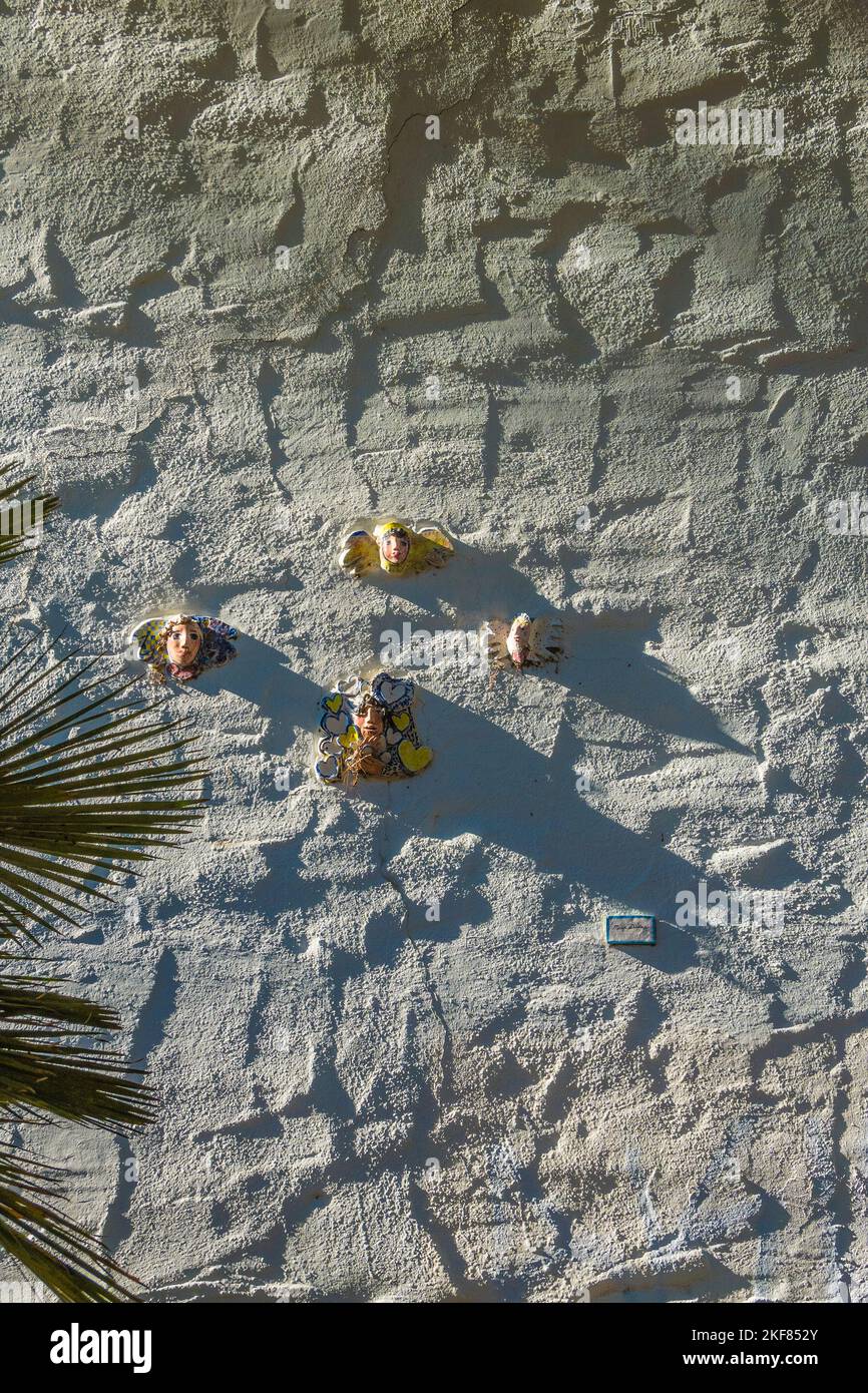 Faces of ceramic people attached to a stucco wall by Santa Barbara ...