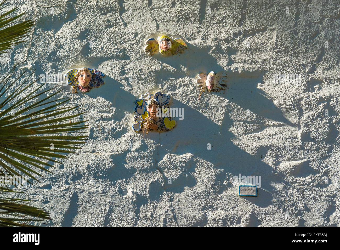 Faces of ceramic people attached to a stucco wall by Santa Barbara ...