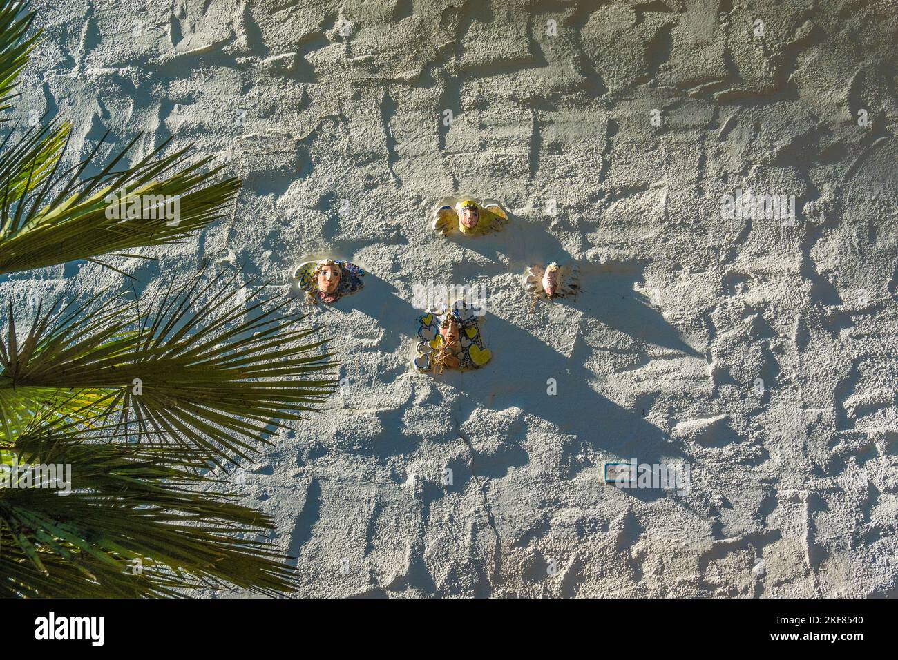 Faces of ceramic people attached to a stucco wall by Santa Barbara ...