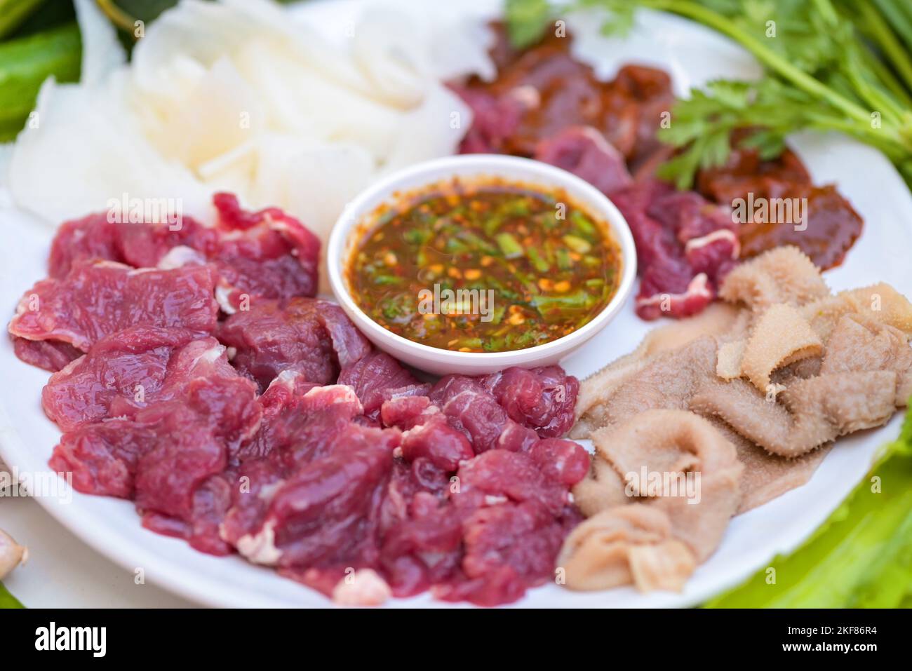 beef sashimi meat - raw beef slice on plate with fresh vegetables and ...
