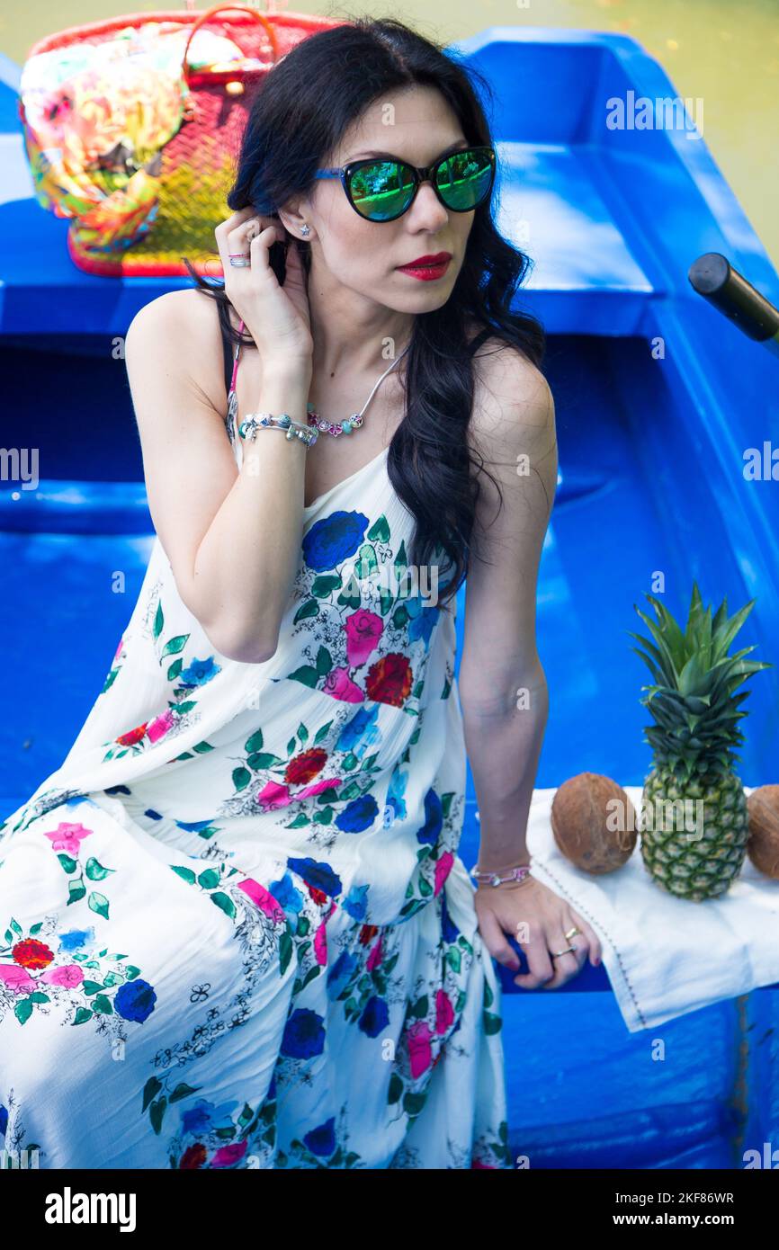 A vertical shot of a young Caucasian woman in a summer dress on a sunny ...