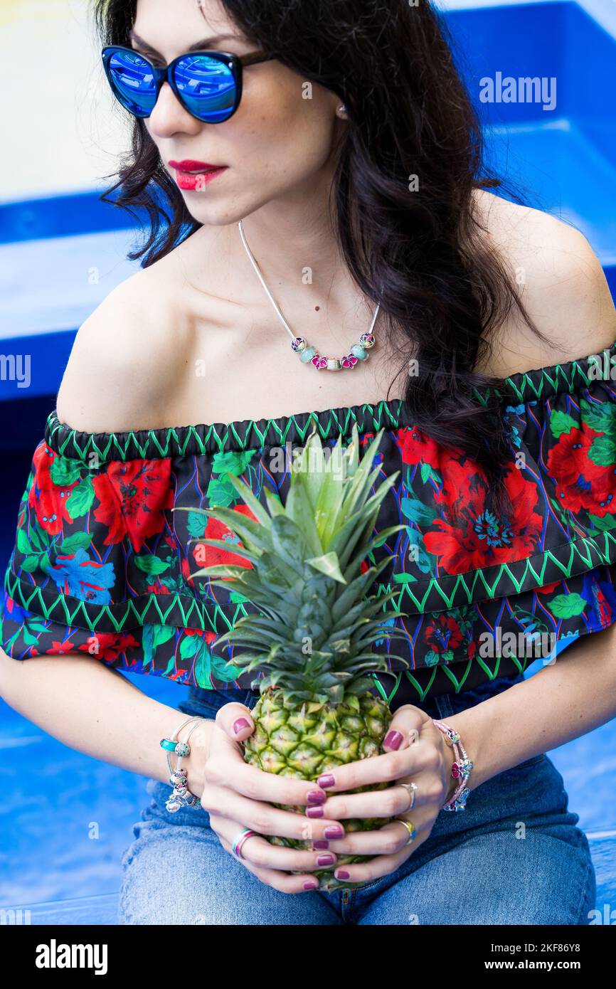 A vertical shot of a young Caucasian woman in a summer dress on a sunny ...