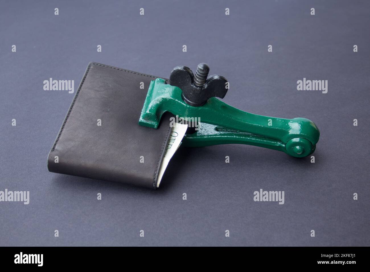 Image of a wallet with a dollar bill showing through and a clamp that ...