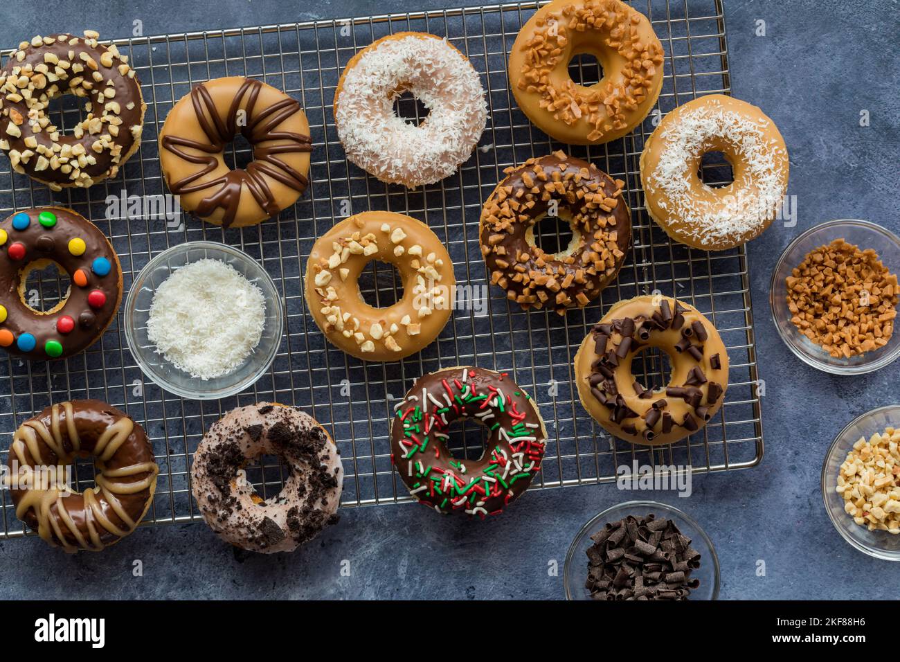 Assorted homemade donuts with various glazes and toppings, on a cooling ...