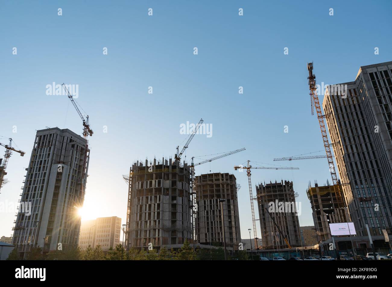 Tall buildings under construction and cranes under a blue sky Stock ...
