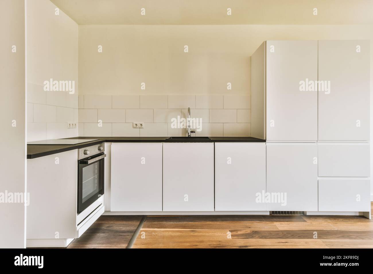 Interior of empty white kitchen with windows and wooden parquet floor ...