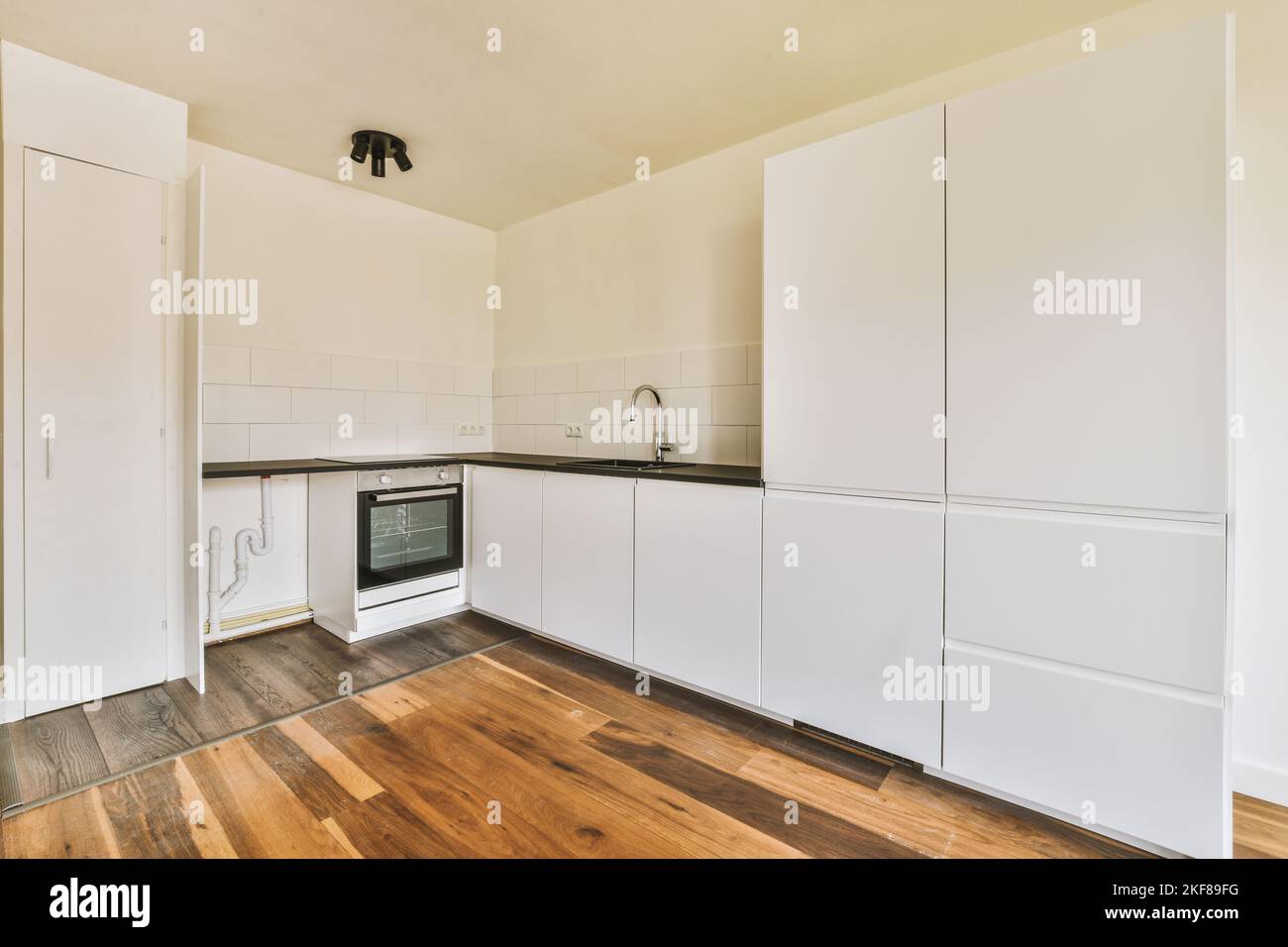 Interior of empty white kitchen with windows and wooden parquet floor ...