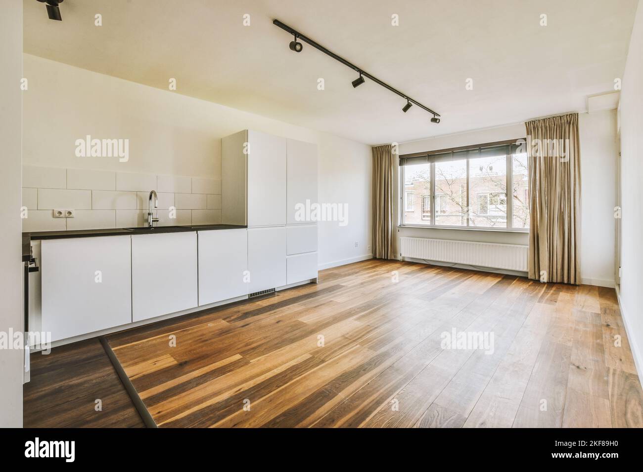 Interior of empty white kitchen with windows and wooden parquet floor ...