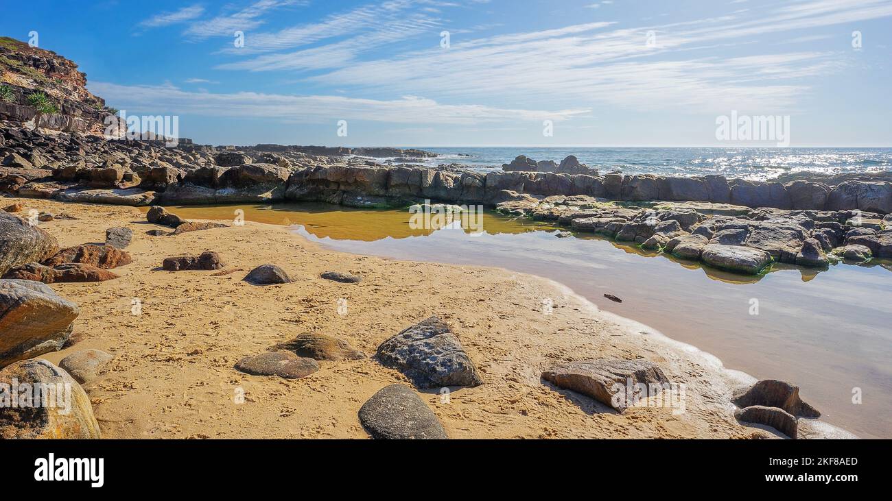 Pool of salt water on the rocky Headland at Point Arkwright with cloudy ...