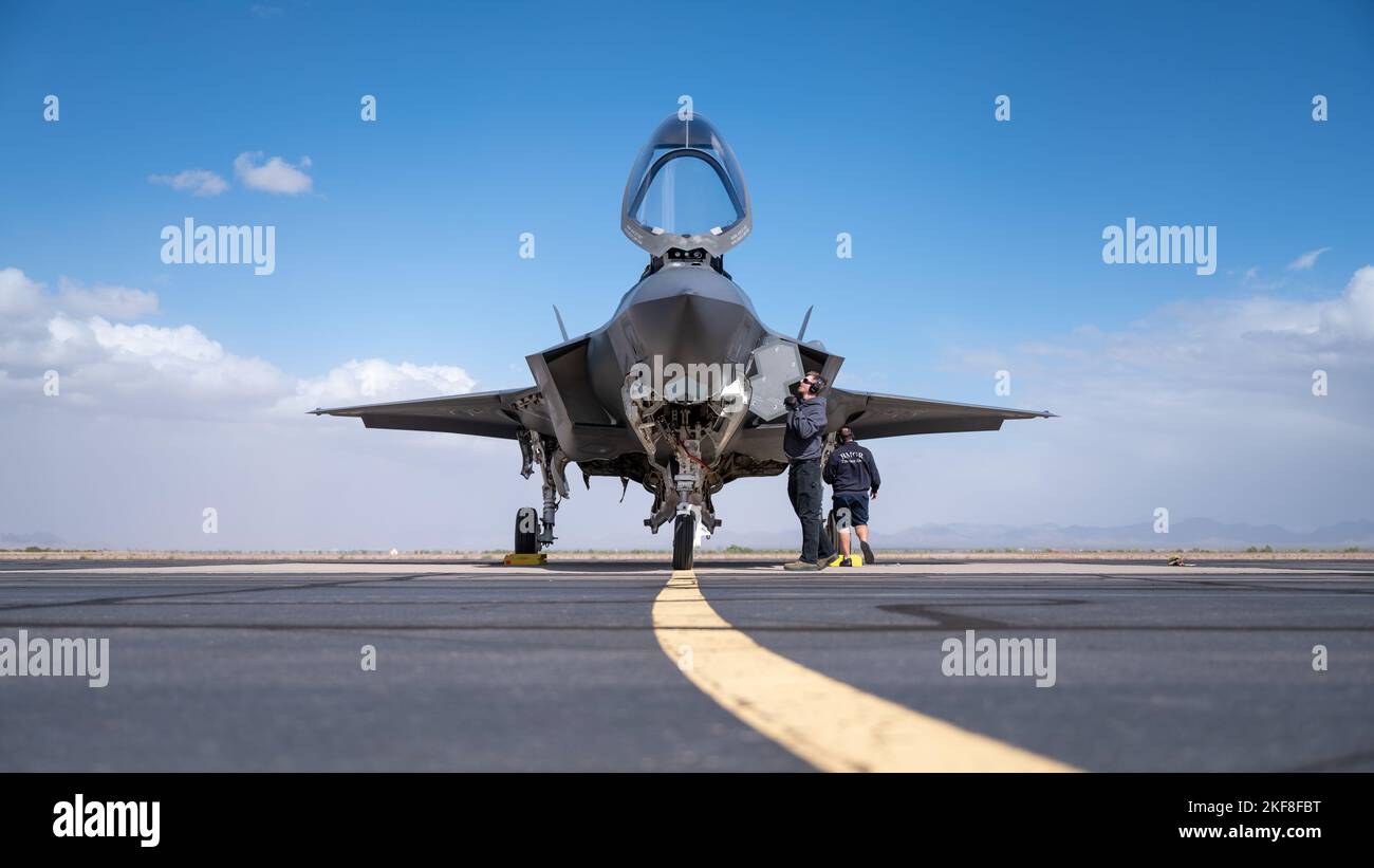Civilian aircraft maintenance technicians perform checks on an F-35 ...