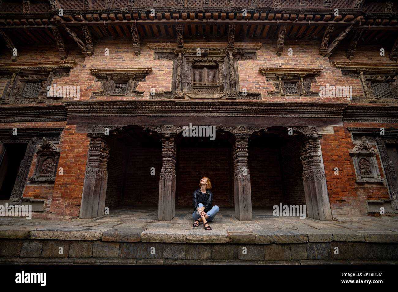 A Caucasian female sitting against the Patan Museum in Kathmandu, Nepal ...