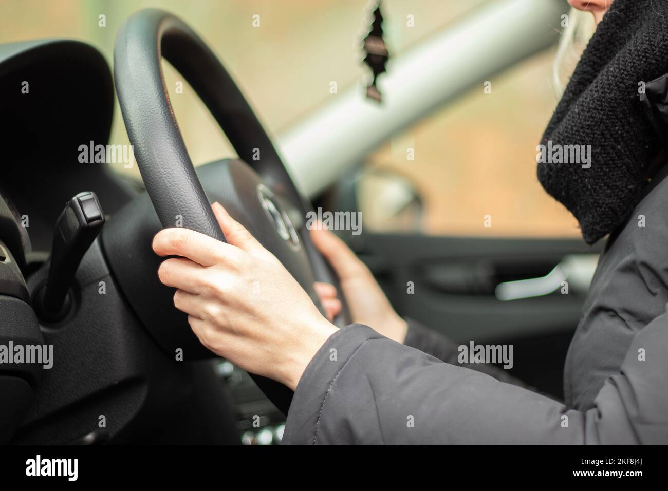 girl driving her own car in motion close-up, hands on the steering ...