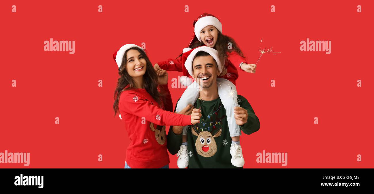 Happy family with Christmas sparklers on red background Stock Photo - Alamy