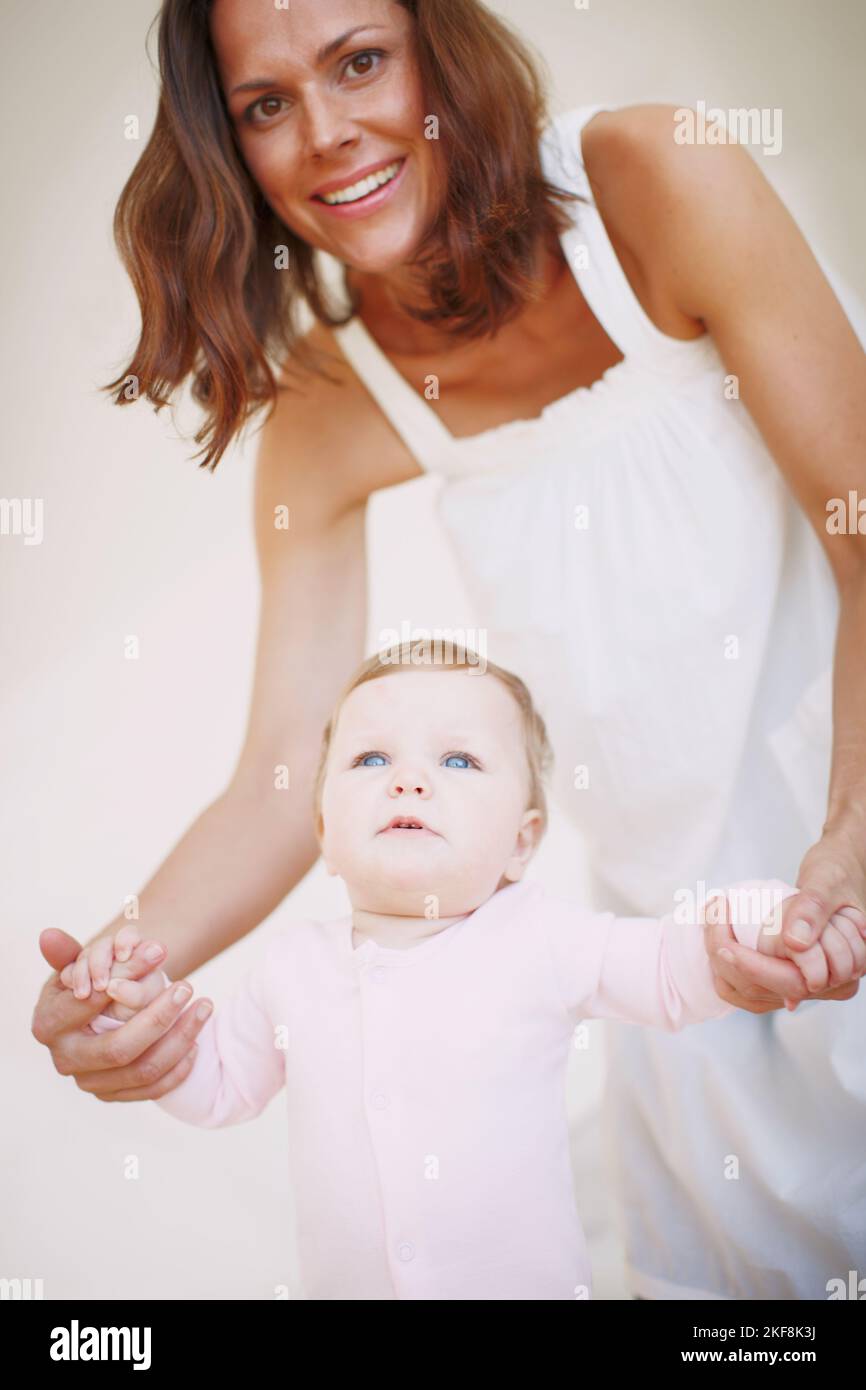 Baby steps- shes almost ready to walk. Portrait of a mother helping her ...