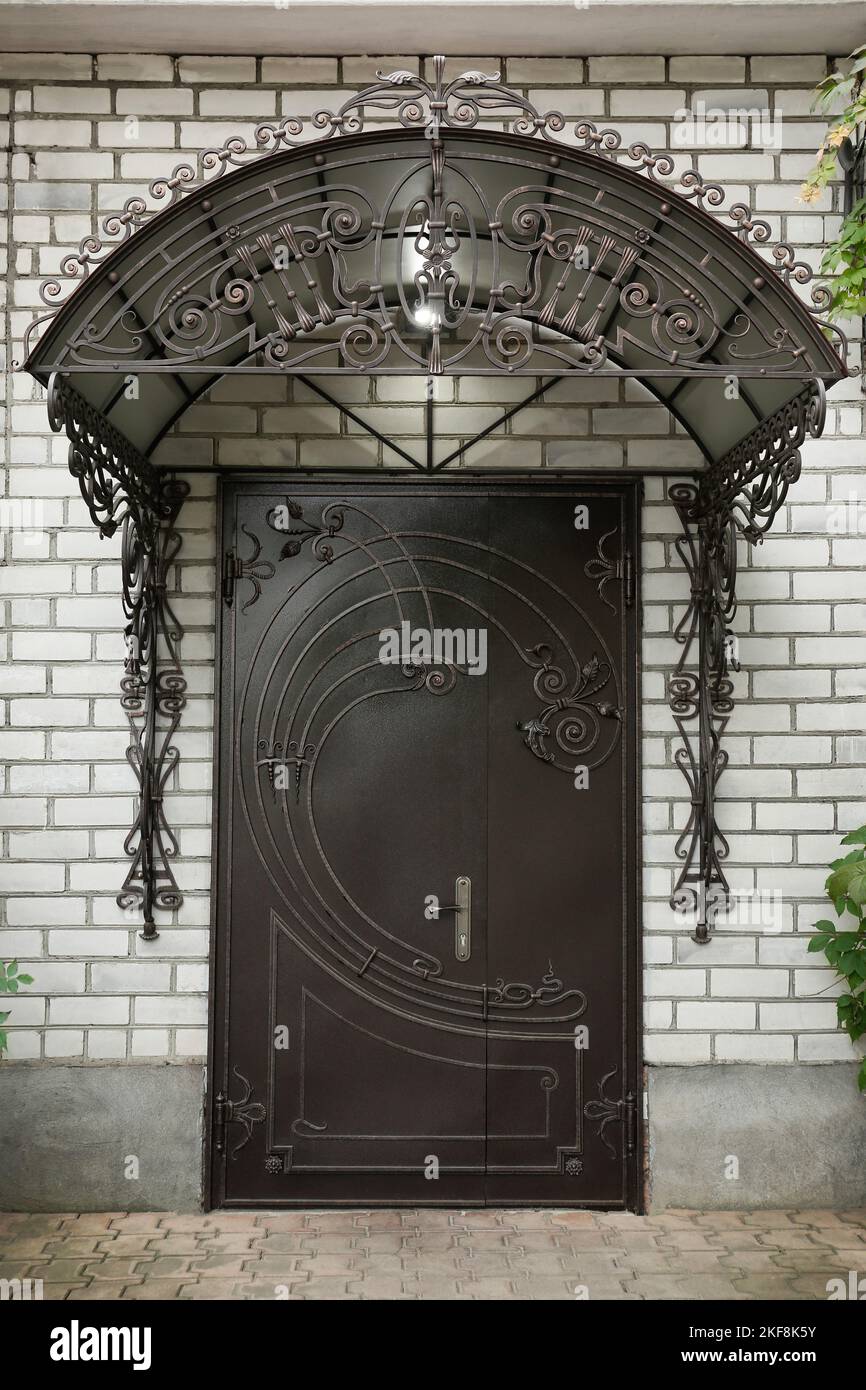 Building with metal door and forged visor Stock Photo - Alamy