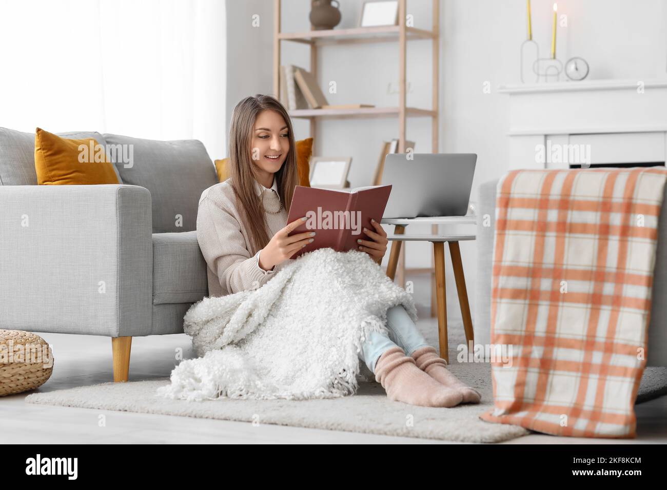 Young woman with warm plaid reading book at home Stock Photo - Alamy
