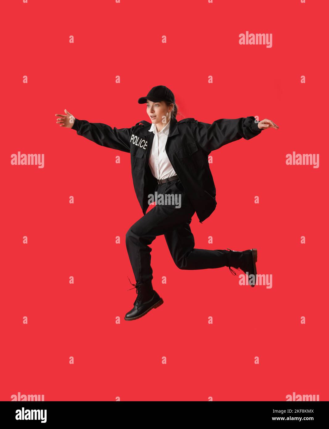 Female police officer jumping on red background Stock Photo - Alamy