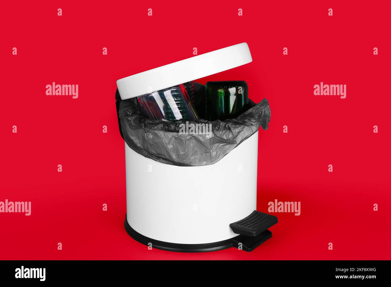 Open rubbish bin with trash on red background Stock Photo - Alamy