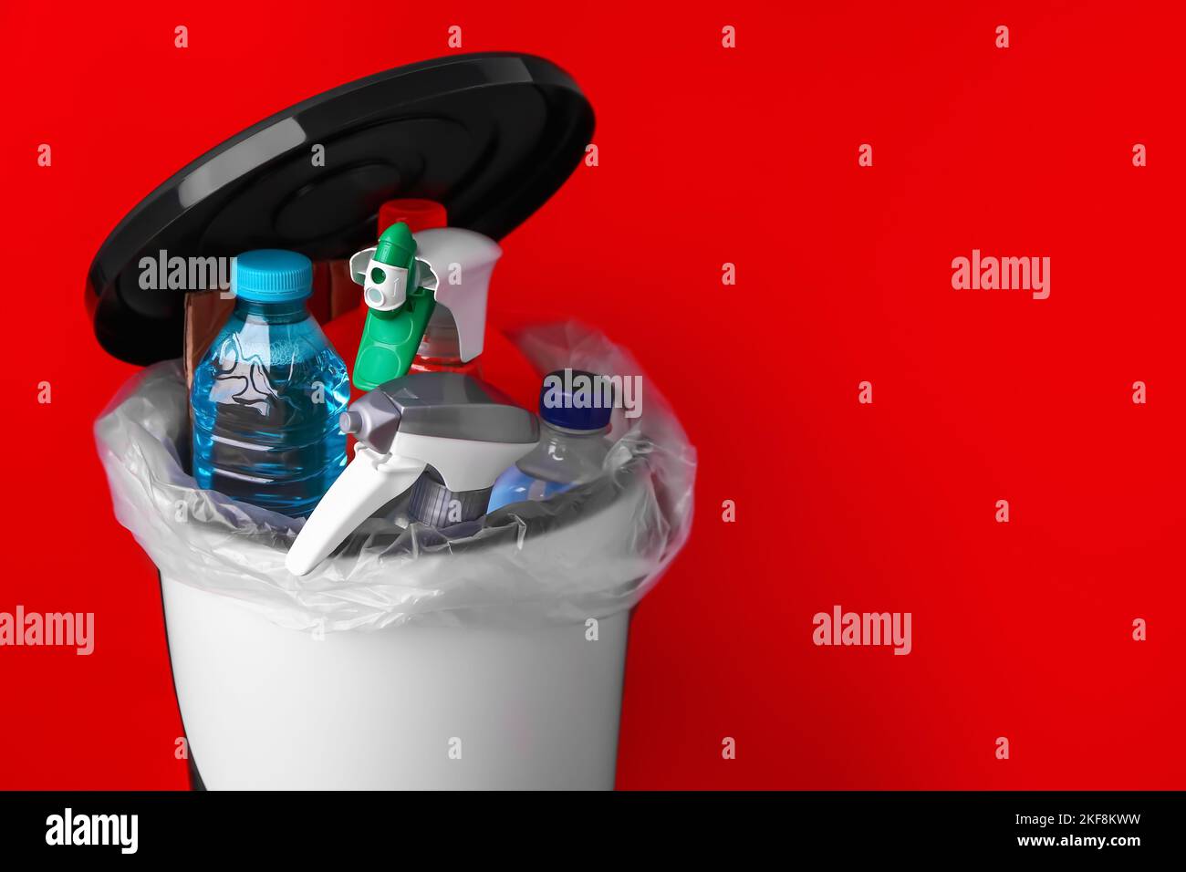 Open rubbish bin with cleaning supplies on red background Stock Photo ...