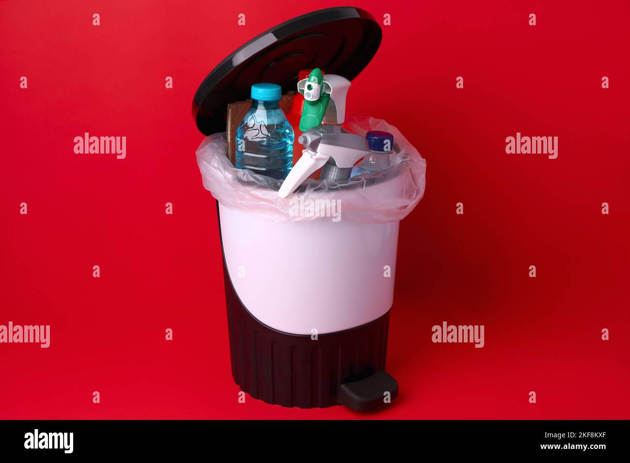 Open rubbish bin with cleaning supplies on red background Stock Photo ...