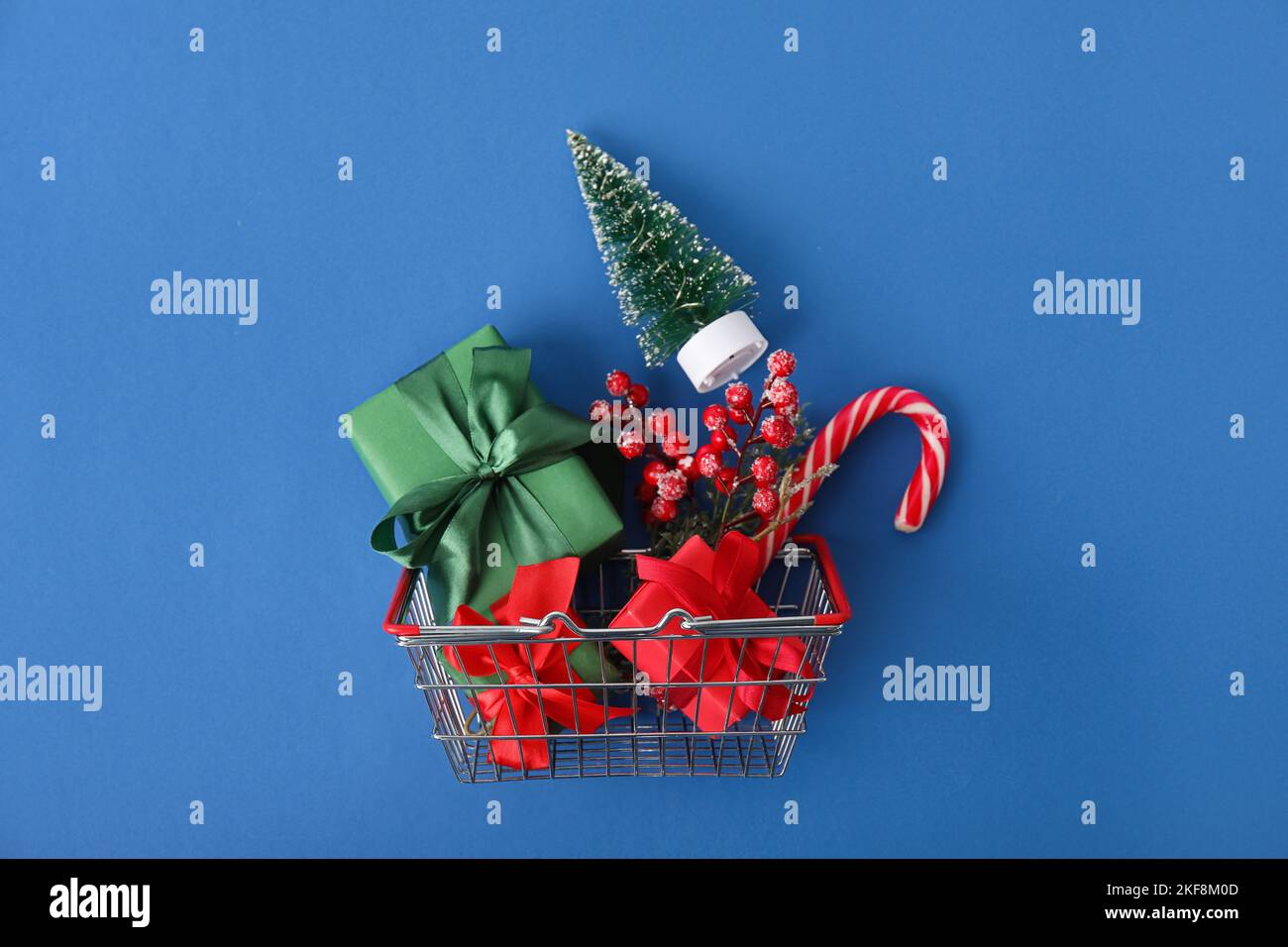 Shopping basket with Christmas tree, gifts, candy cane and rowan on ...