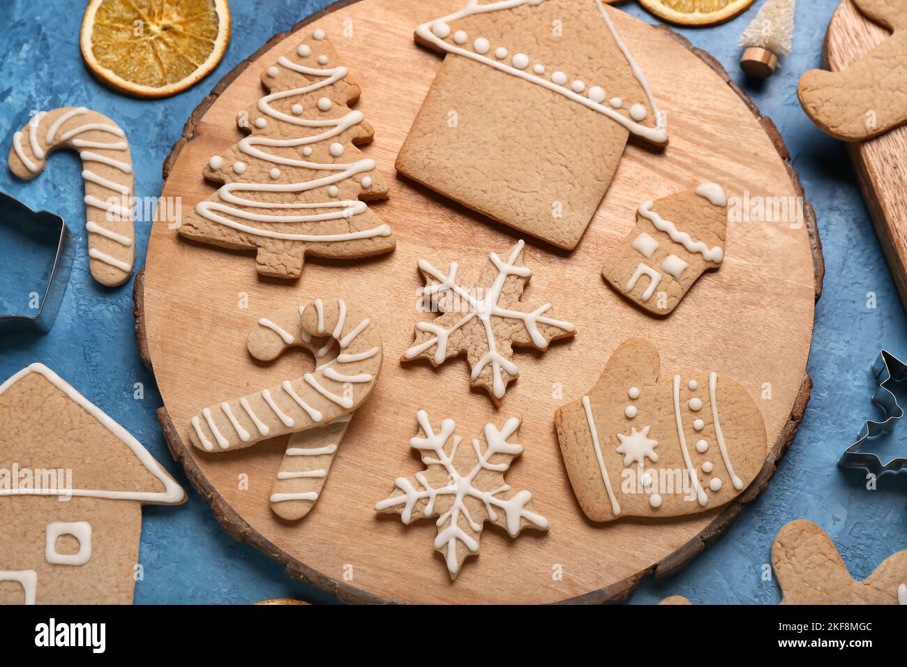 Wooden board with sweet Christmas cookies on color background, closeup ...