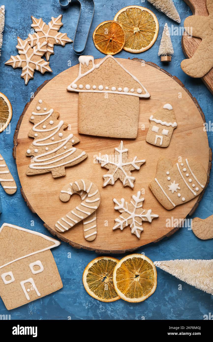Wooden board with tasty Christmas cookies on color background Stock ...