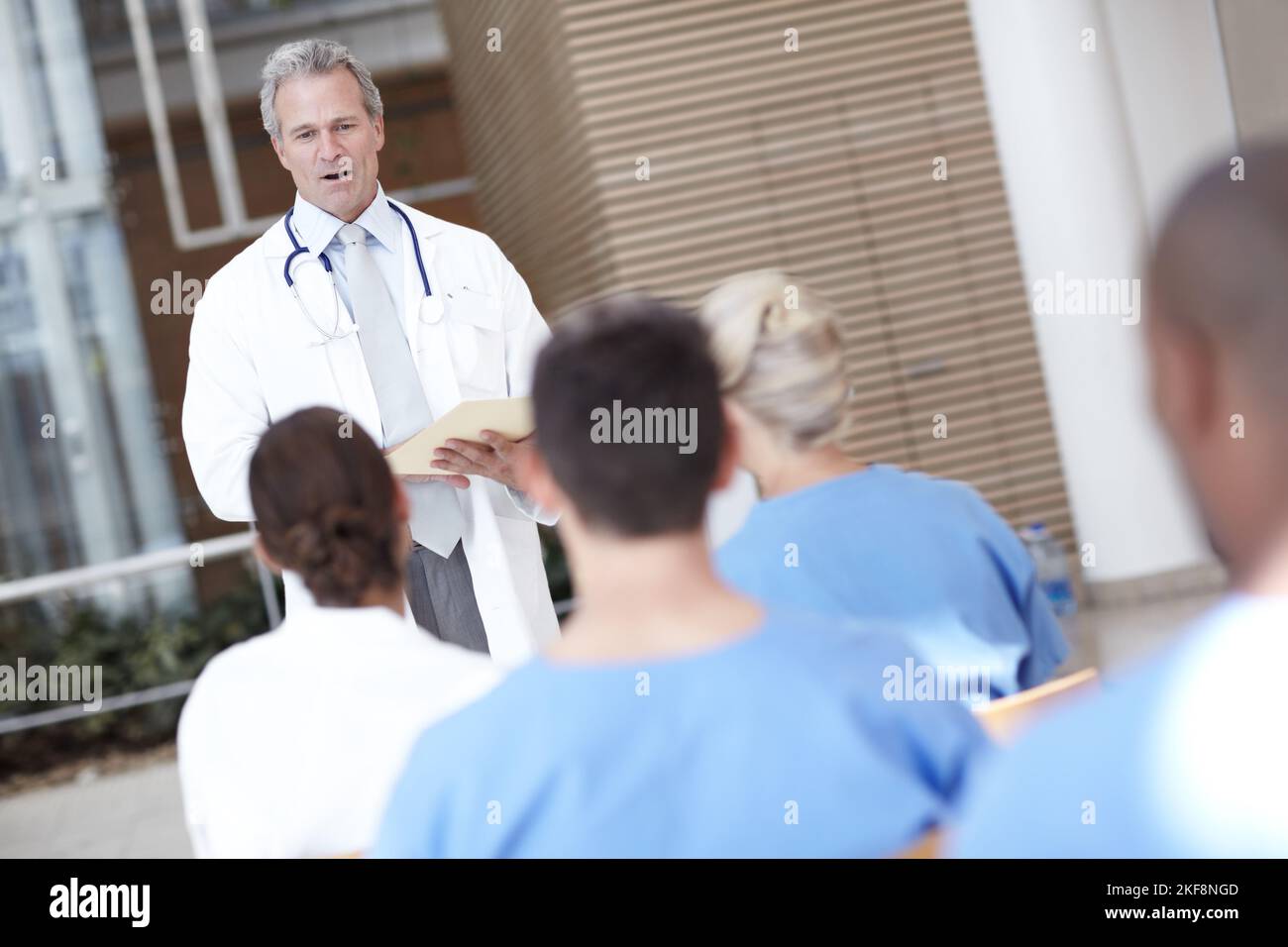 Leading his medical team to success. A doctor delivering a speech in ...
