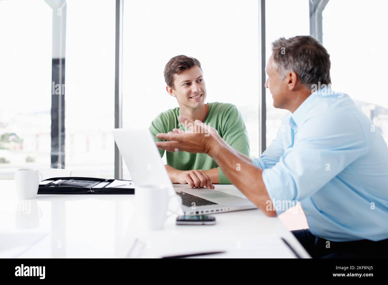 Learning from the best. A mature executive looking over some work on a ...