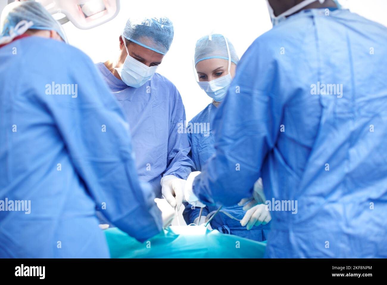 Saving lives. Surgeons performing surgery in an operating theatre Stock ...