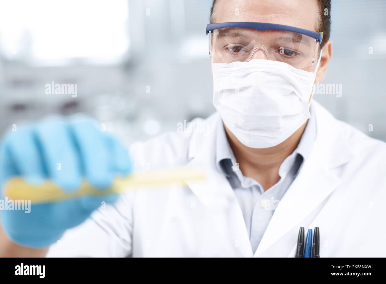 Safety first. Closeup of a chemist in the process of mixing chemicals ...